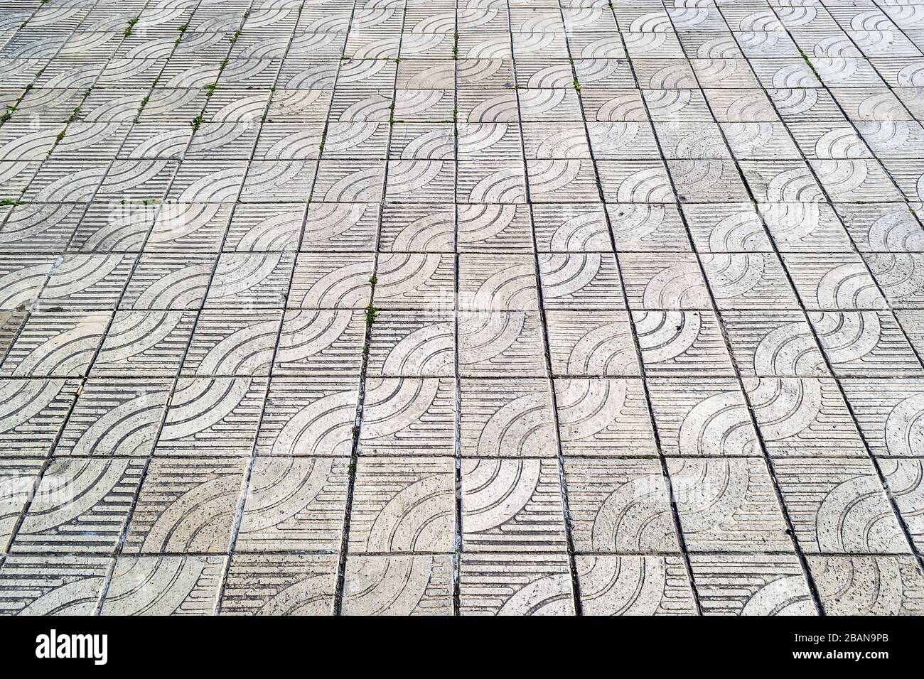 Texture of gray square concrete paving slabs with a stylized wave ...