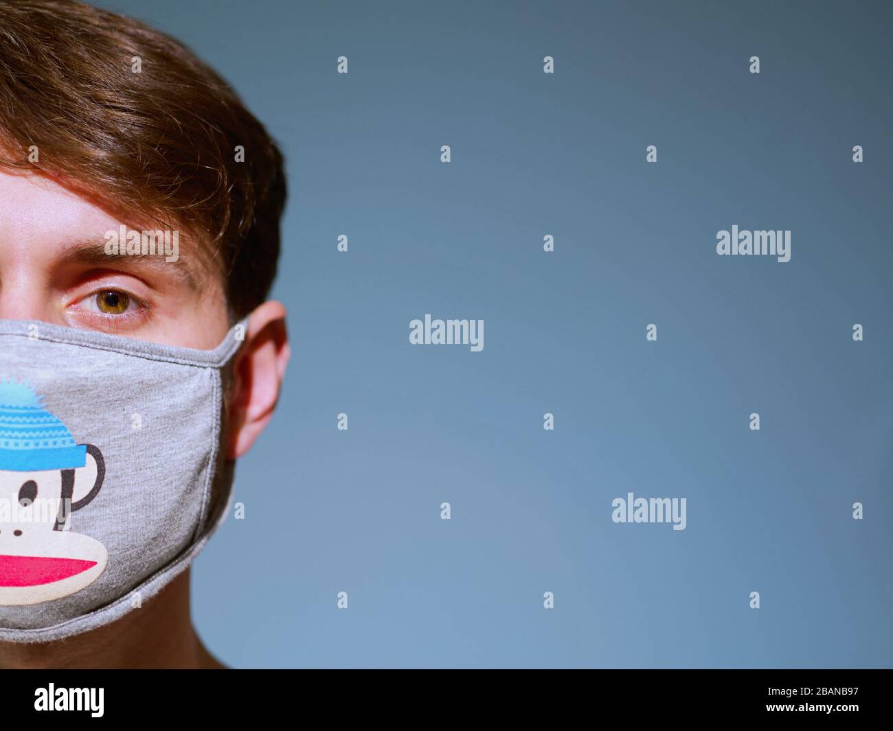 Closeup of a caucasian man face wearing funny monkey face protection ...