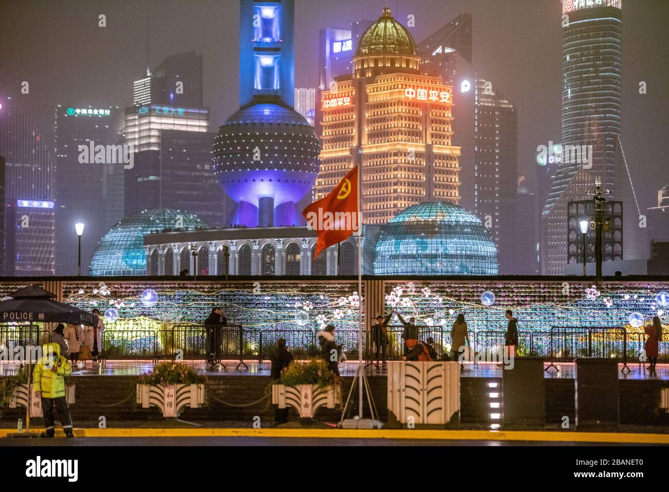 Chinese flag flying in front of the bright cityscape in Shanghai, China ...