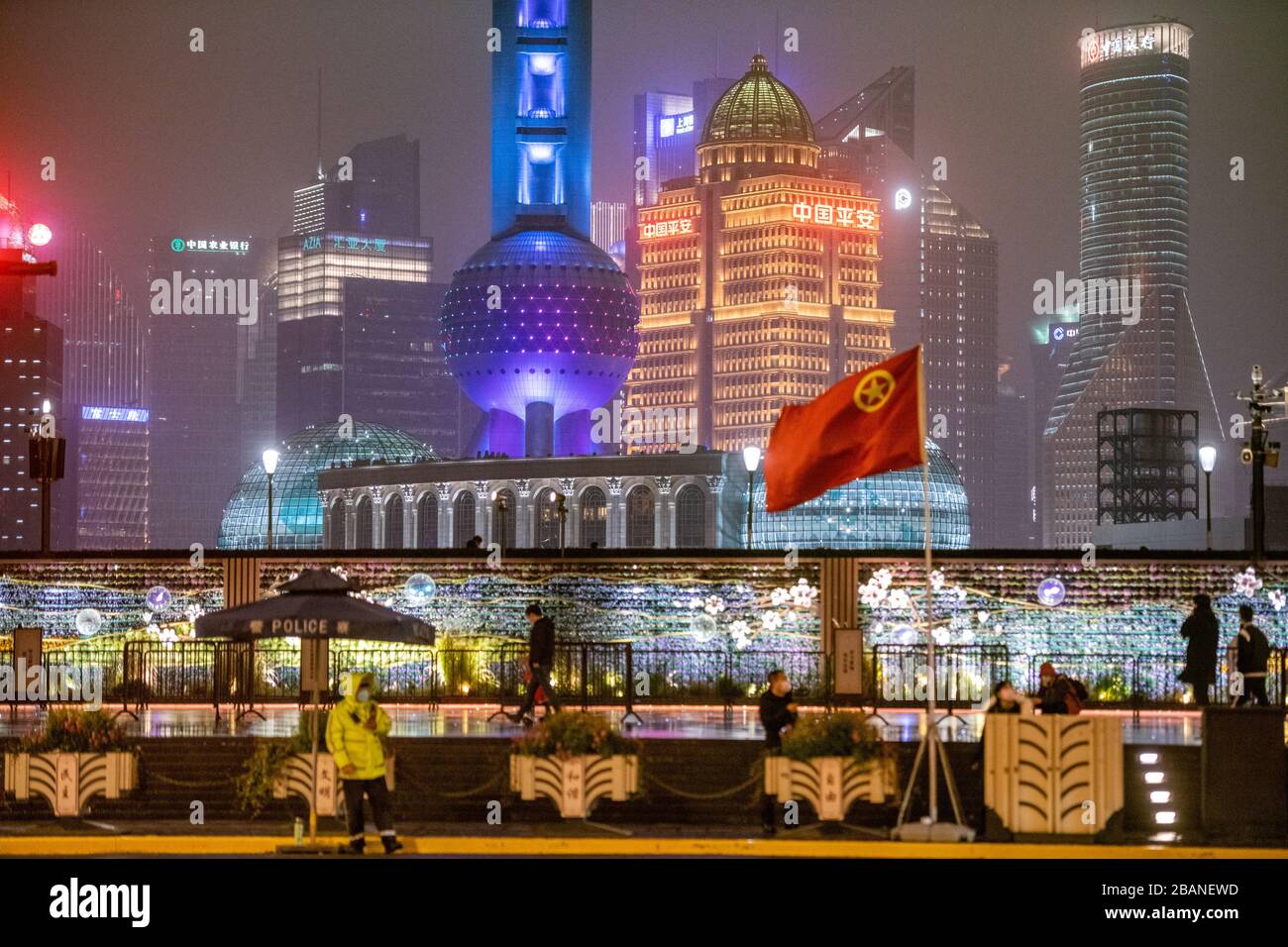 Chinese flag flying in front of the bright cityscape in Shanghai, China ...