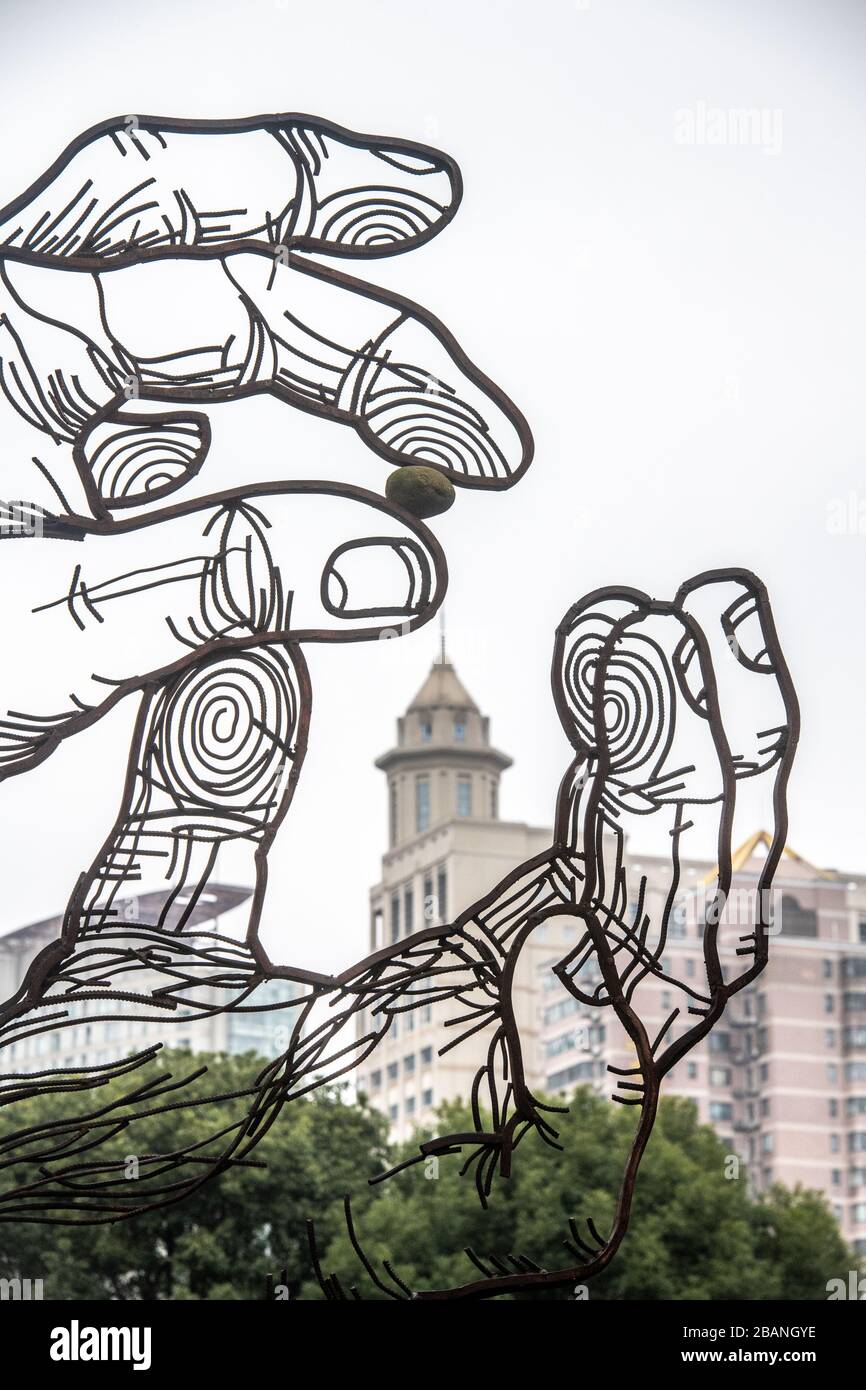 An art installation of hands interacting with a building in the ...