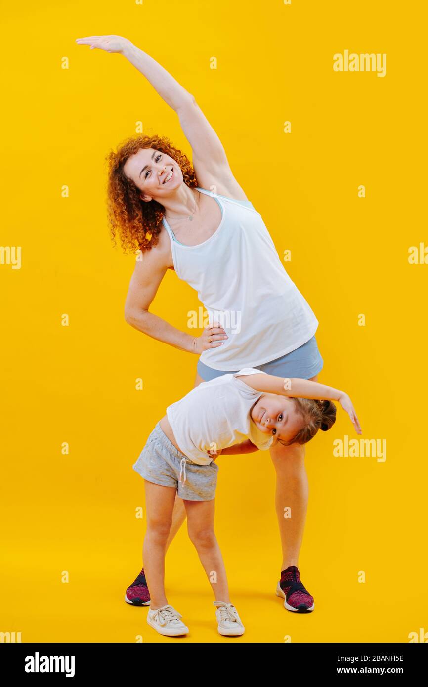 Mom and daughter do exercise tilts to the side Stock Photo - Alamy