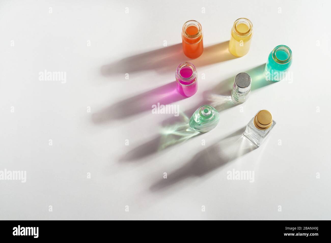 Perfume in a transparent bottle, aromatic oils. Colored shadow on a ...