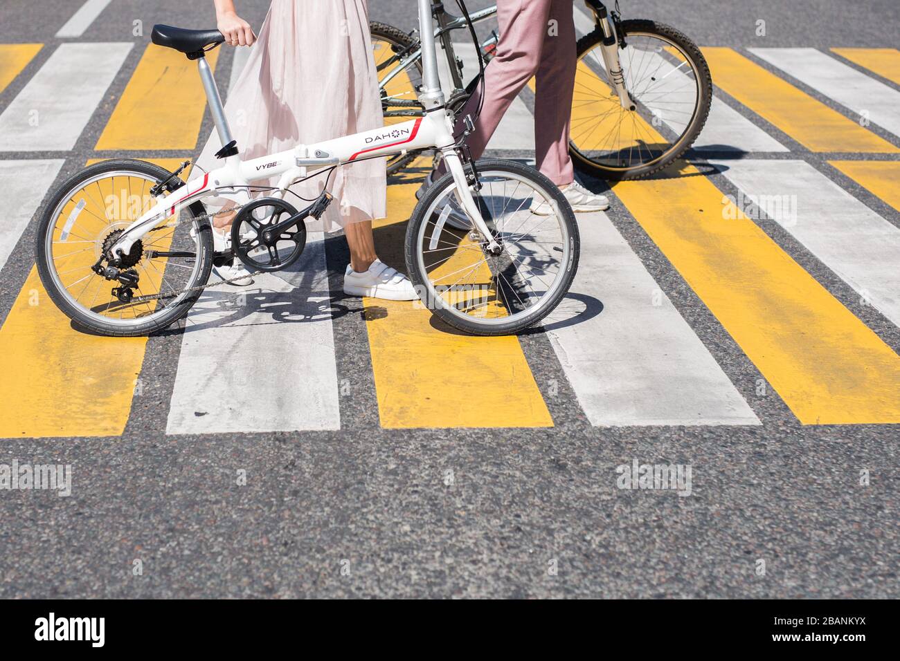 young woman legs and man legs walking with bikes on cross road Stock ...