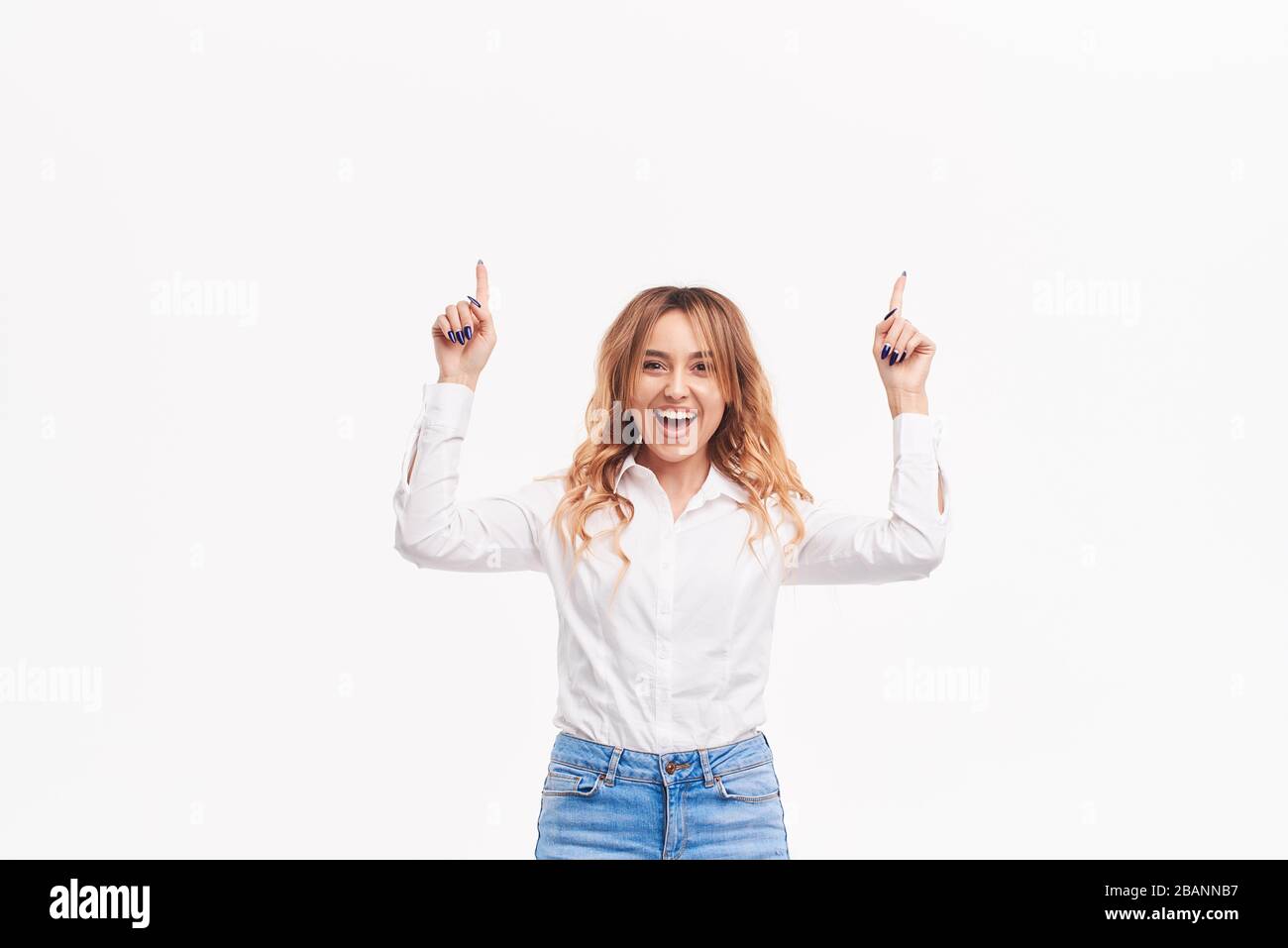 Happy surprised young woman smiling broadly at camera, pointing fingers ...