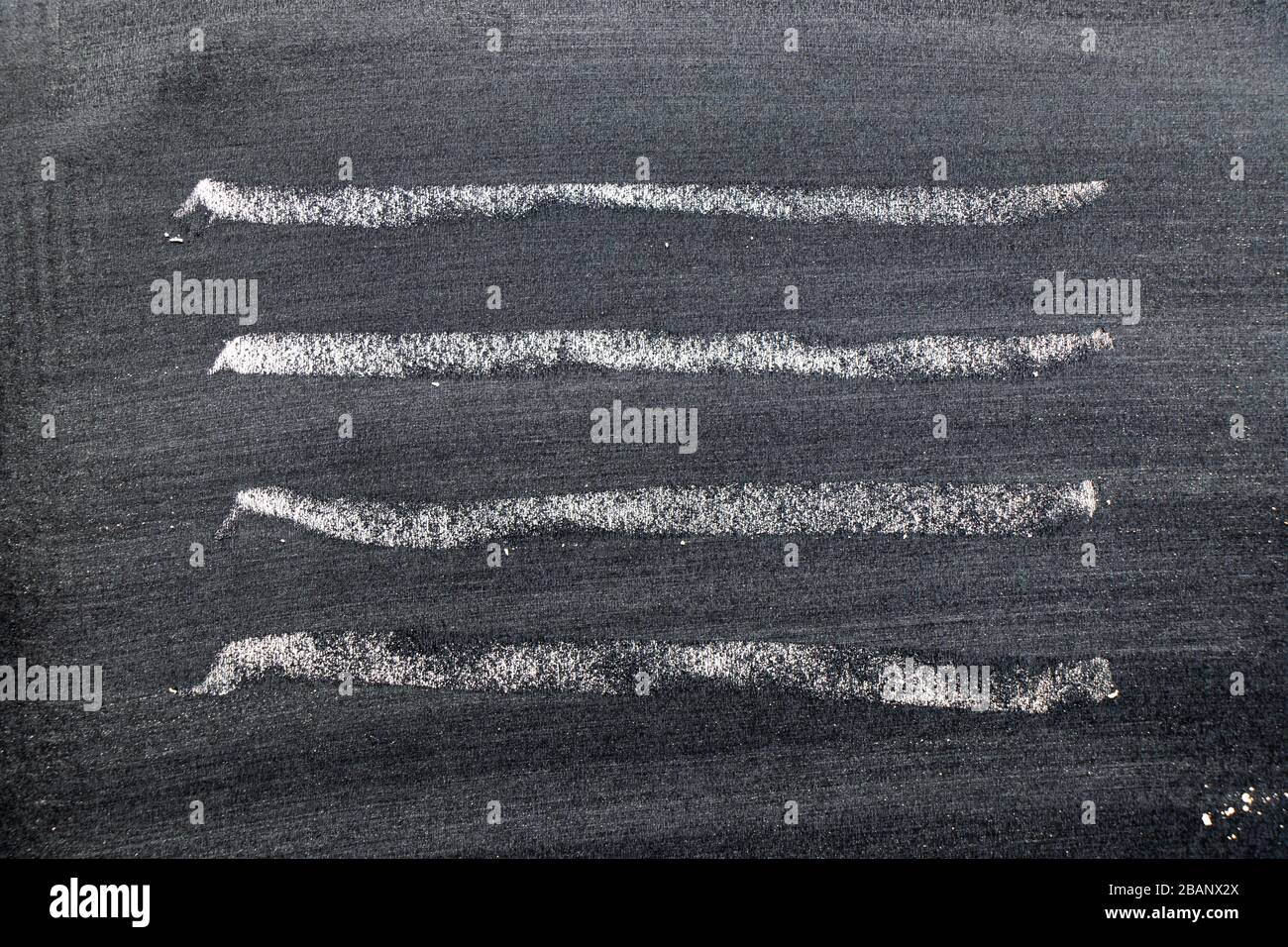 White color chalk hand drawing in set of wavy line shape on black board ...
