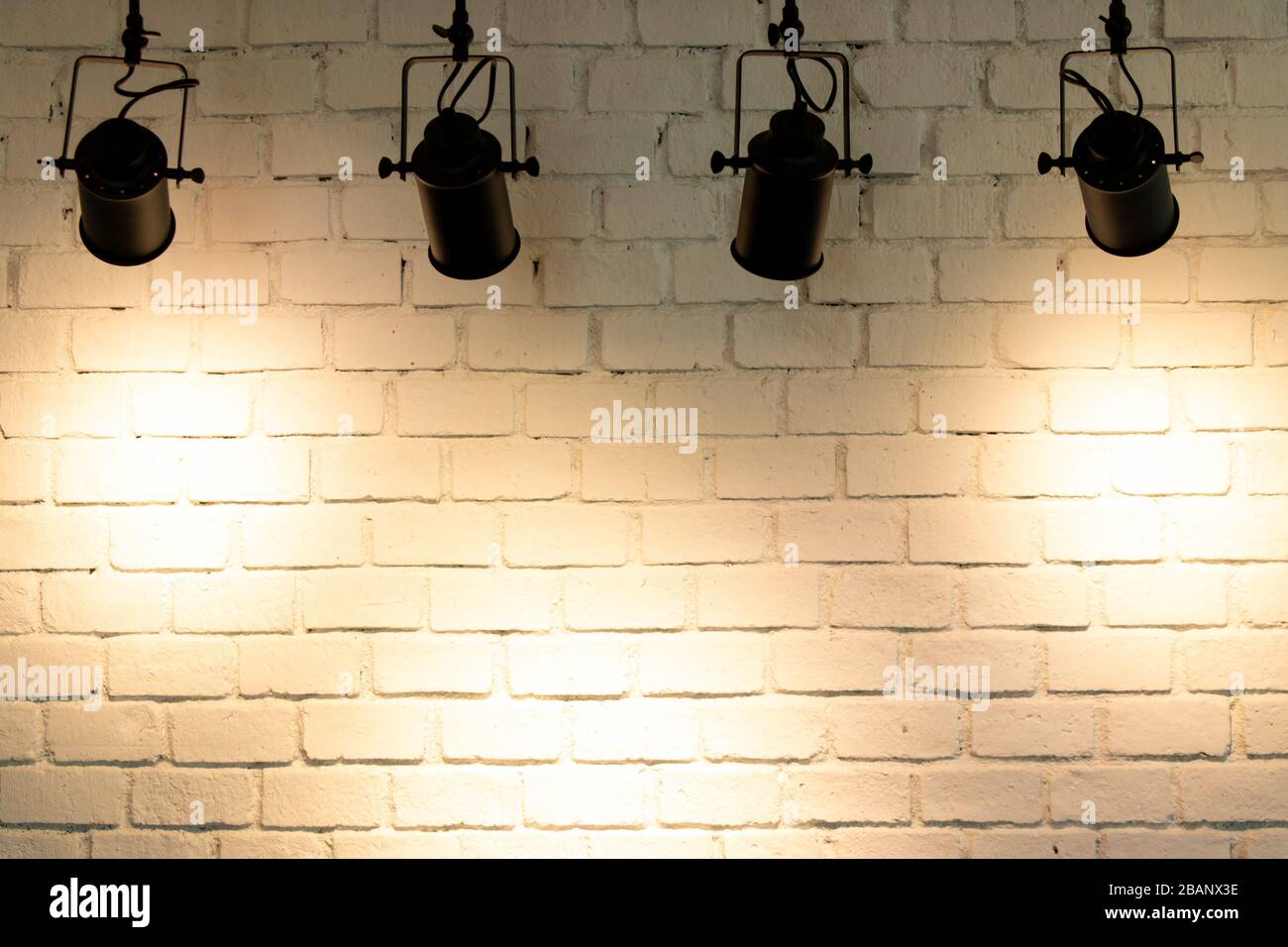 Hanging spotlight illuminate at brick wall background with copy space ...