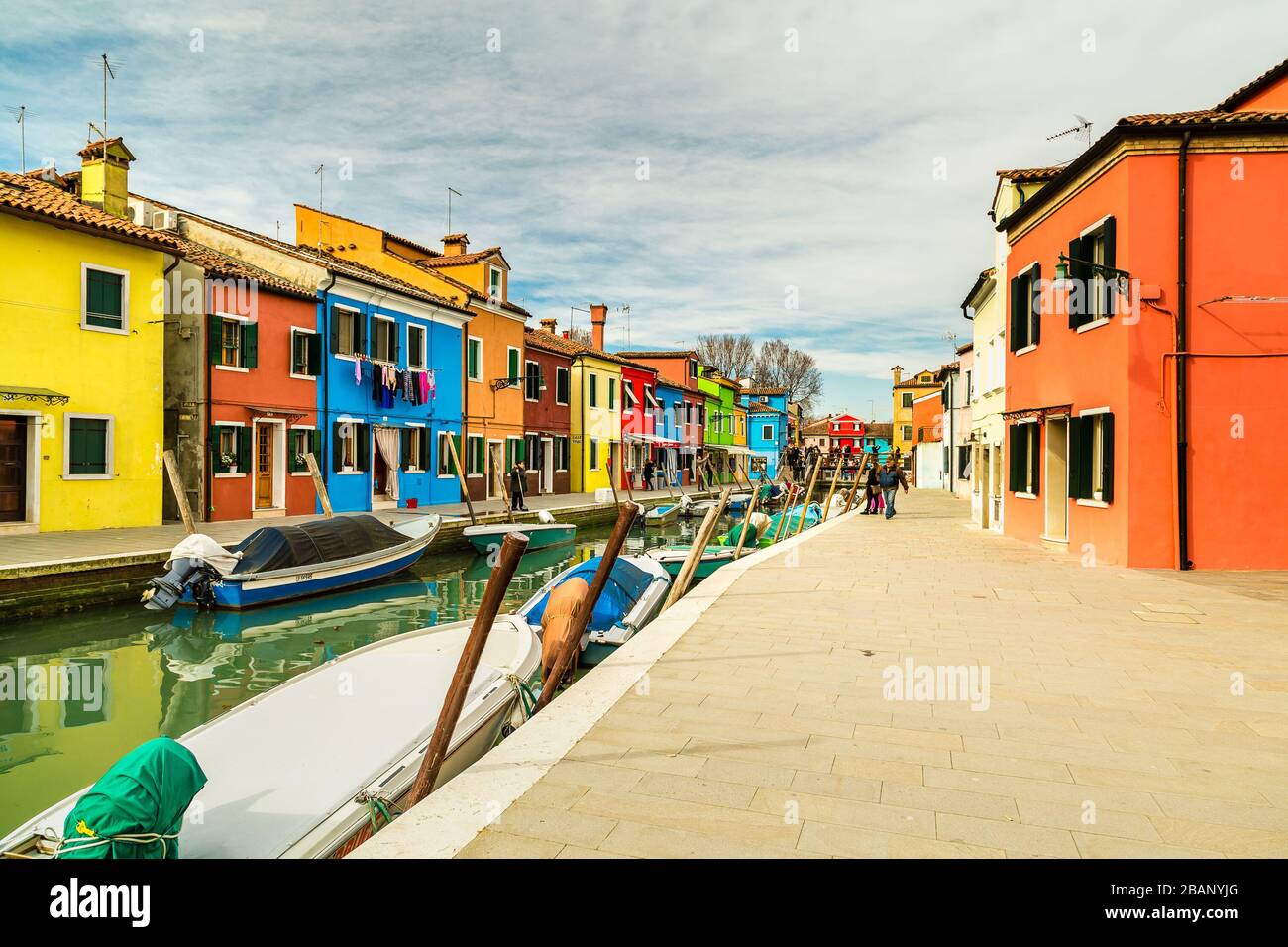 BURANO (VE), ITALY - FEBRUARY 21, 2020: tourists walking along the colorful houses of the ...