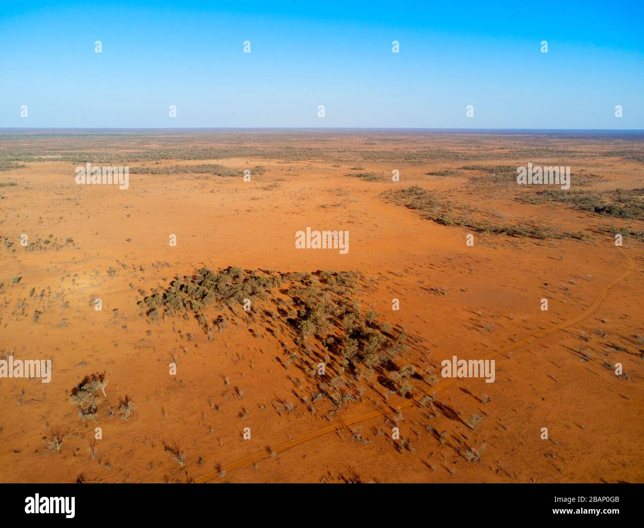 Aerial of lonely station dirt track crossing the drought affected red ...