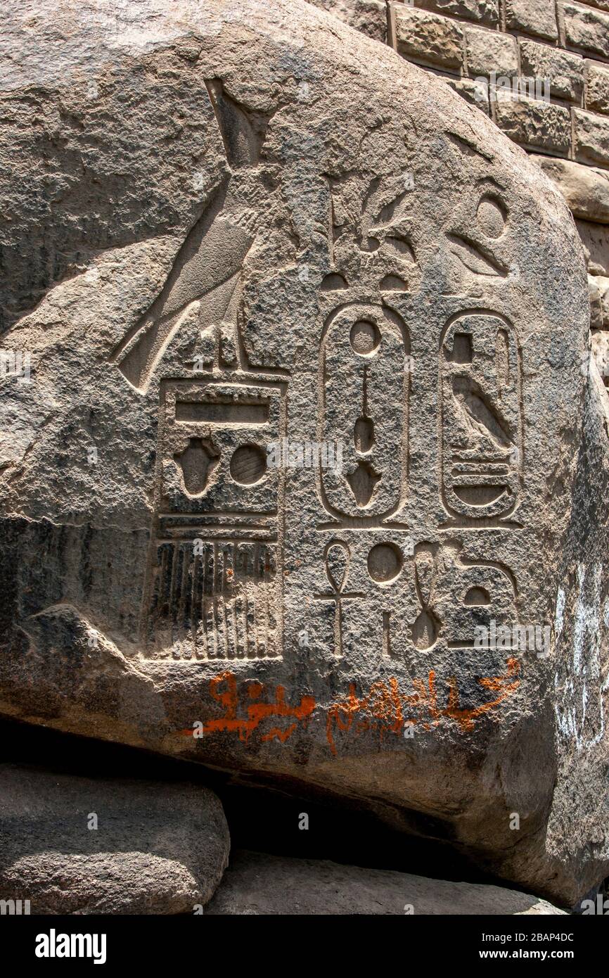Ancient hieroglyphs and relief engravings carved into a rock sitting ...