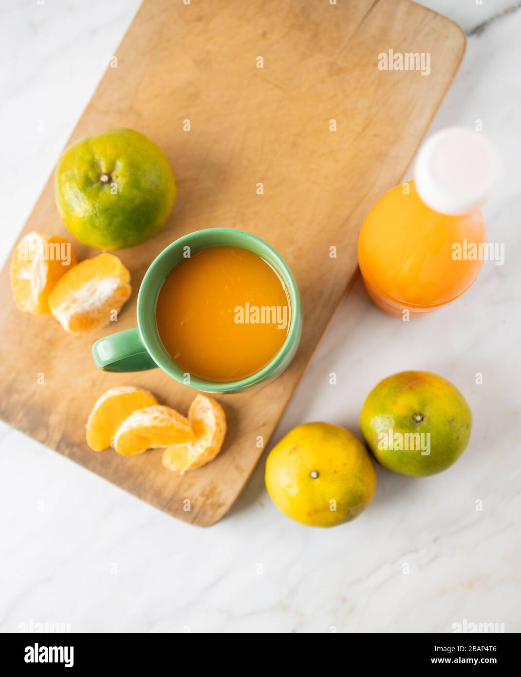 This is the picture of Orange Juice in a cup and in a bottle on marble ...