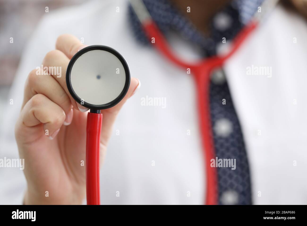 Doctor in white coat shows stethoscope membrane Stock Photo - Alamy