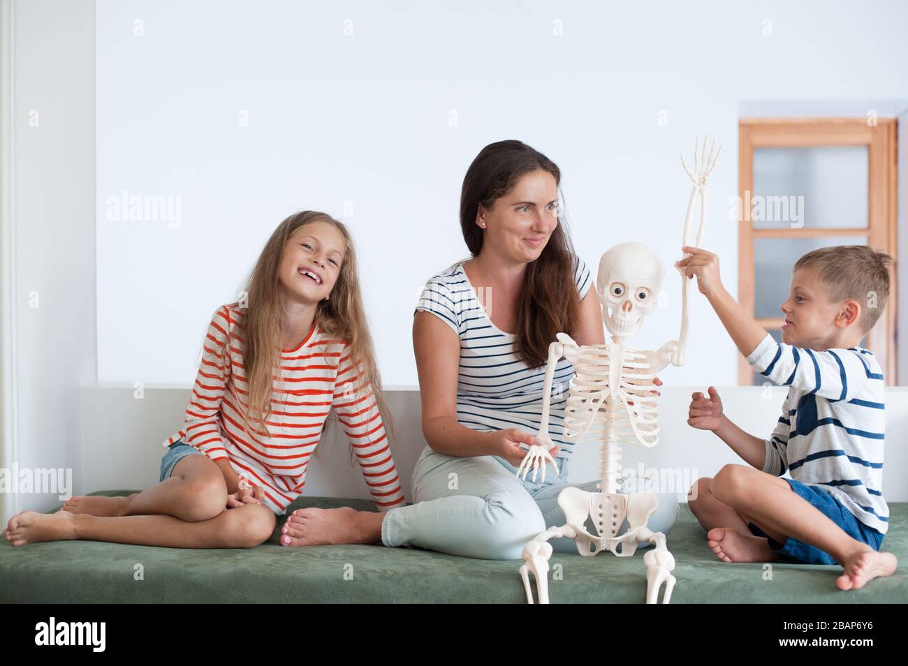 funny kid with mother and sister playing prank skeleton family during ...