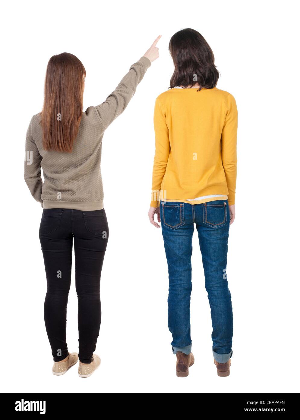 Back view of two pointing girl in sweater. Rear view people collection ...