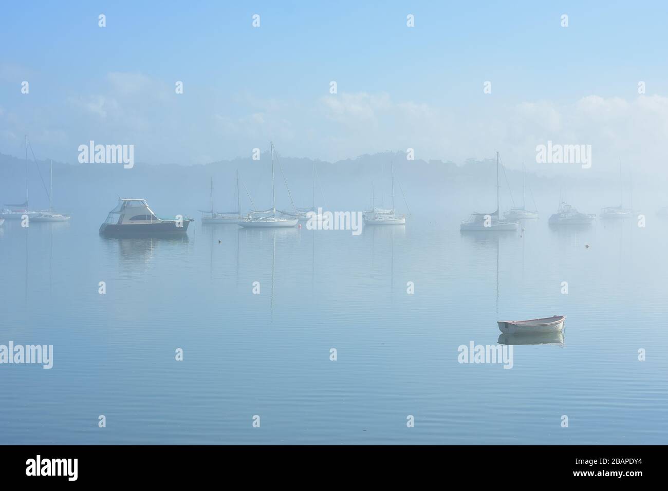 Power and sail boats anchored in flat calm harbor appearing from ...