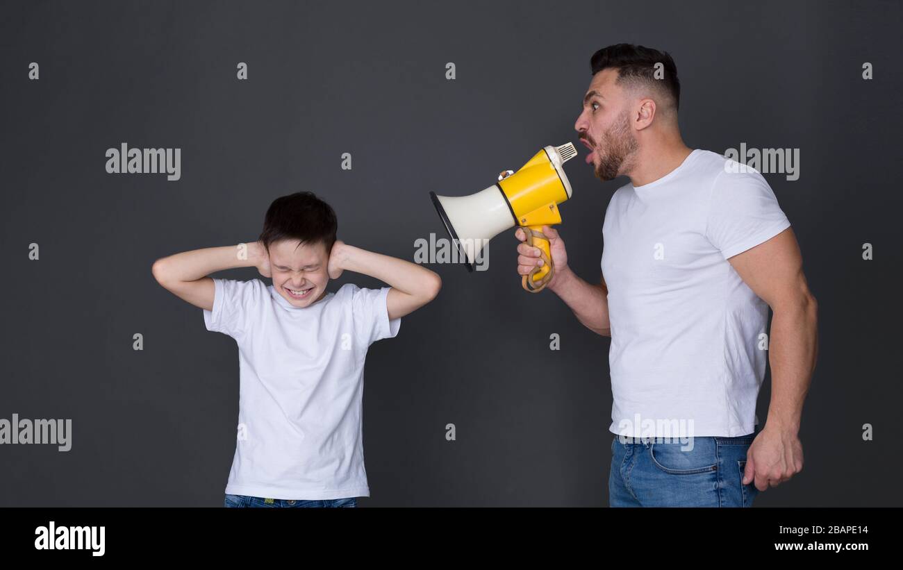 Nervous father screaming at son with megaphone Stock Photo - Alamy