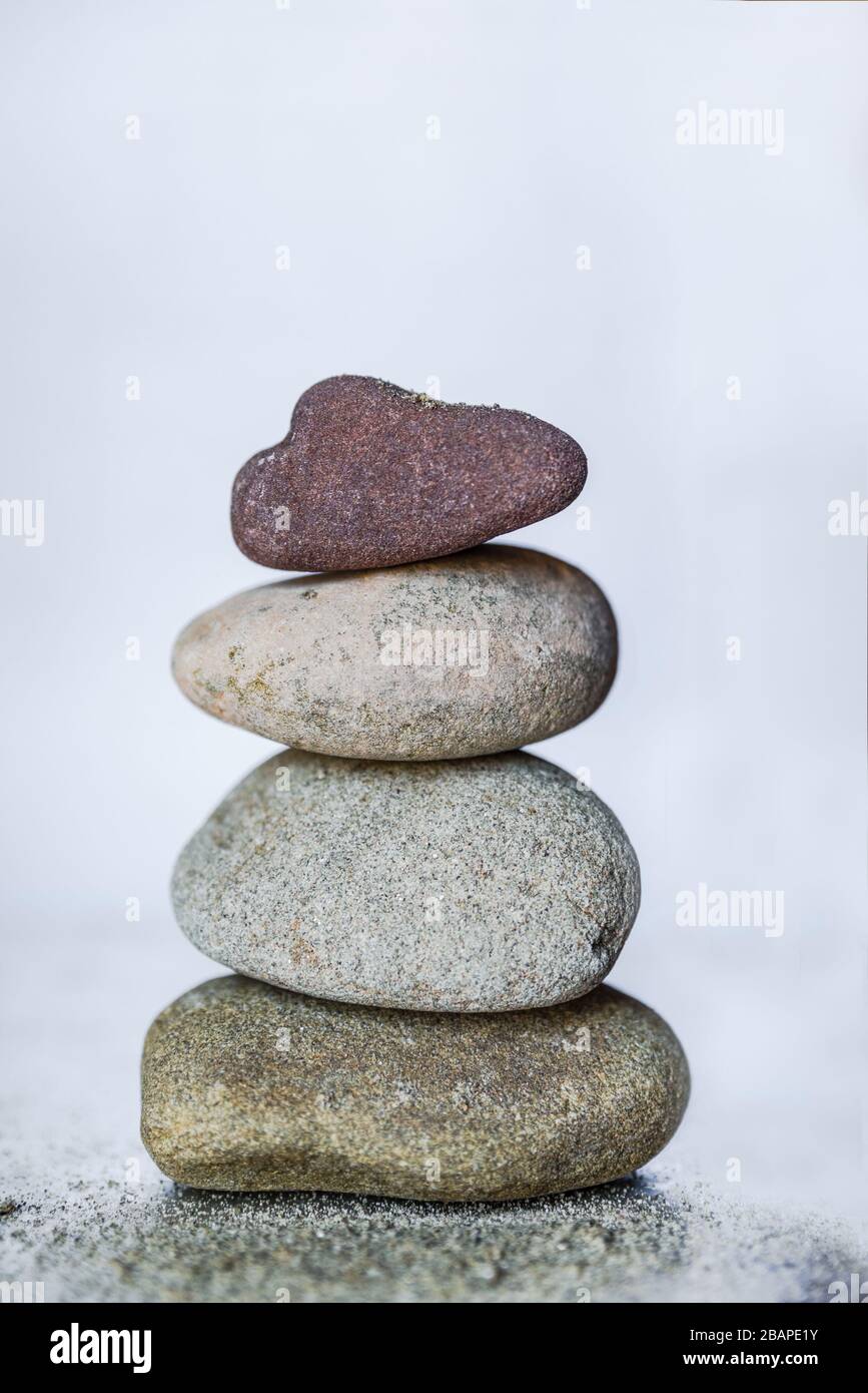 Four colored pebble Stones stacked on bright white background Stock ...