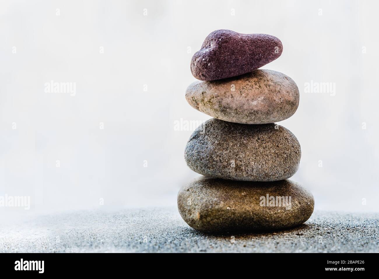 Four colored pebble Stones stacked on bright white background Stock ...