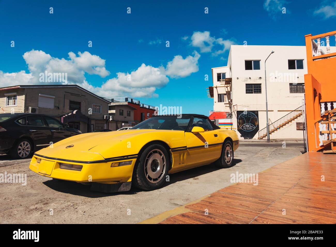 an old yellow 1980s Chevrolet Corvette C4 convertible parked in ...