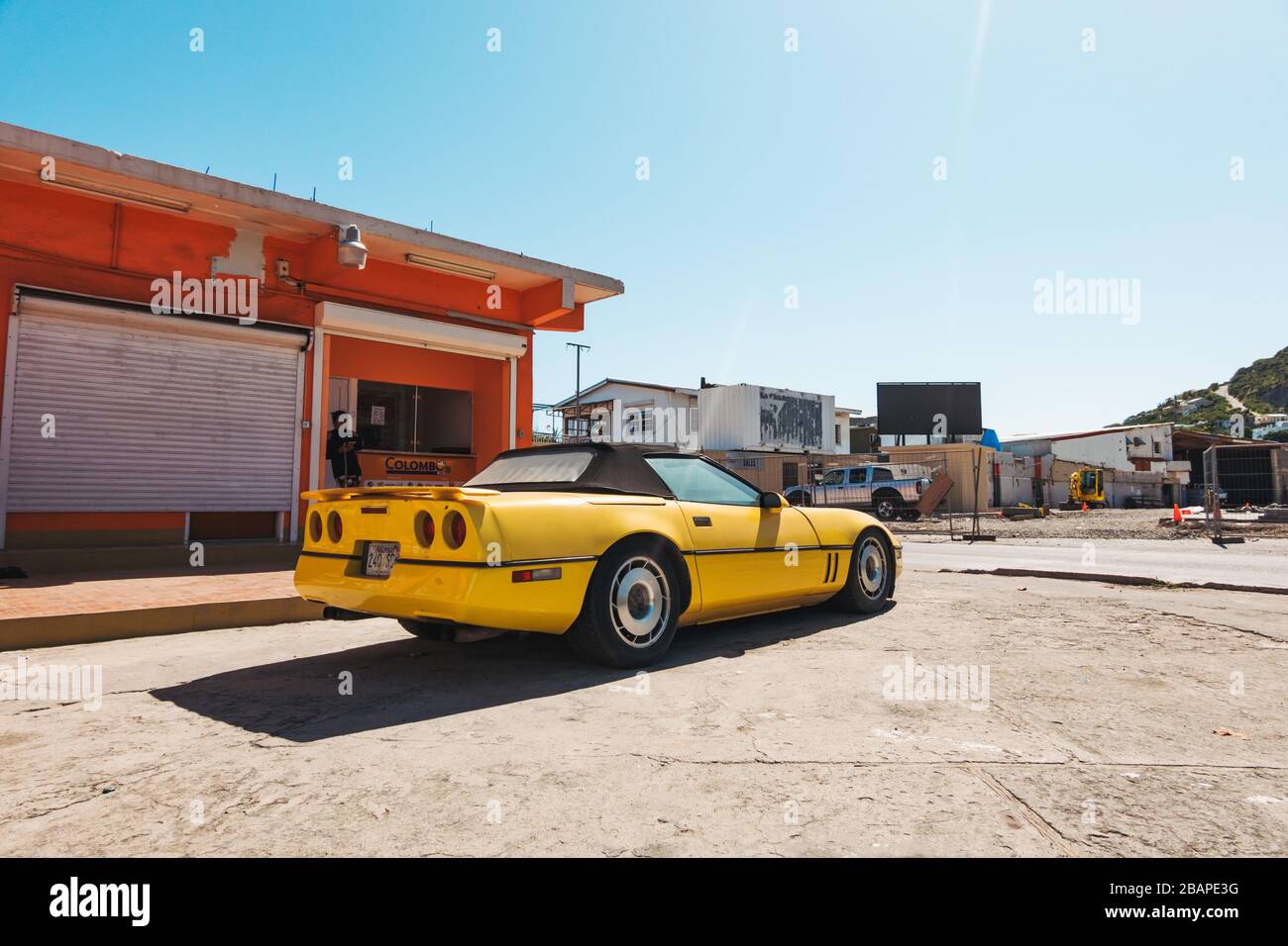 an old yellow 1980s Chevrolet Corvette C4 convertible parked in ...