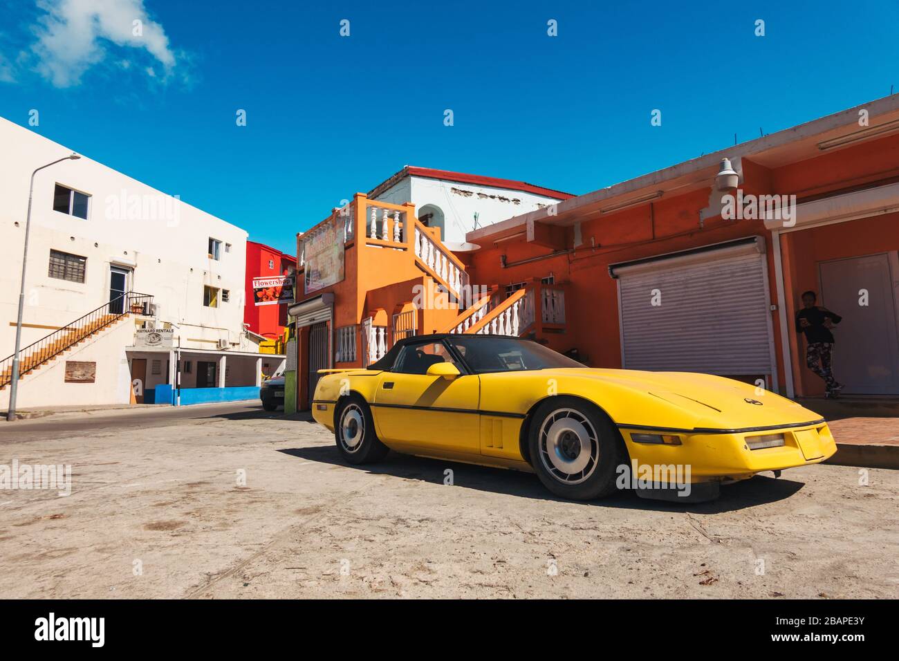 an old yellow 1980s Chevrolet Corvette C4 convertible parked in ...