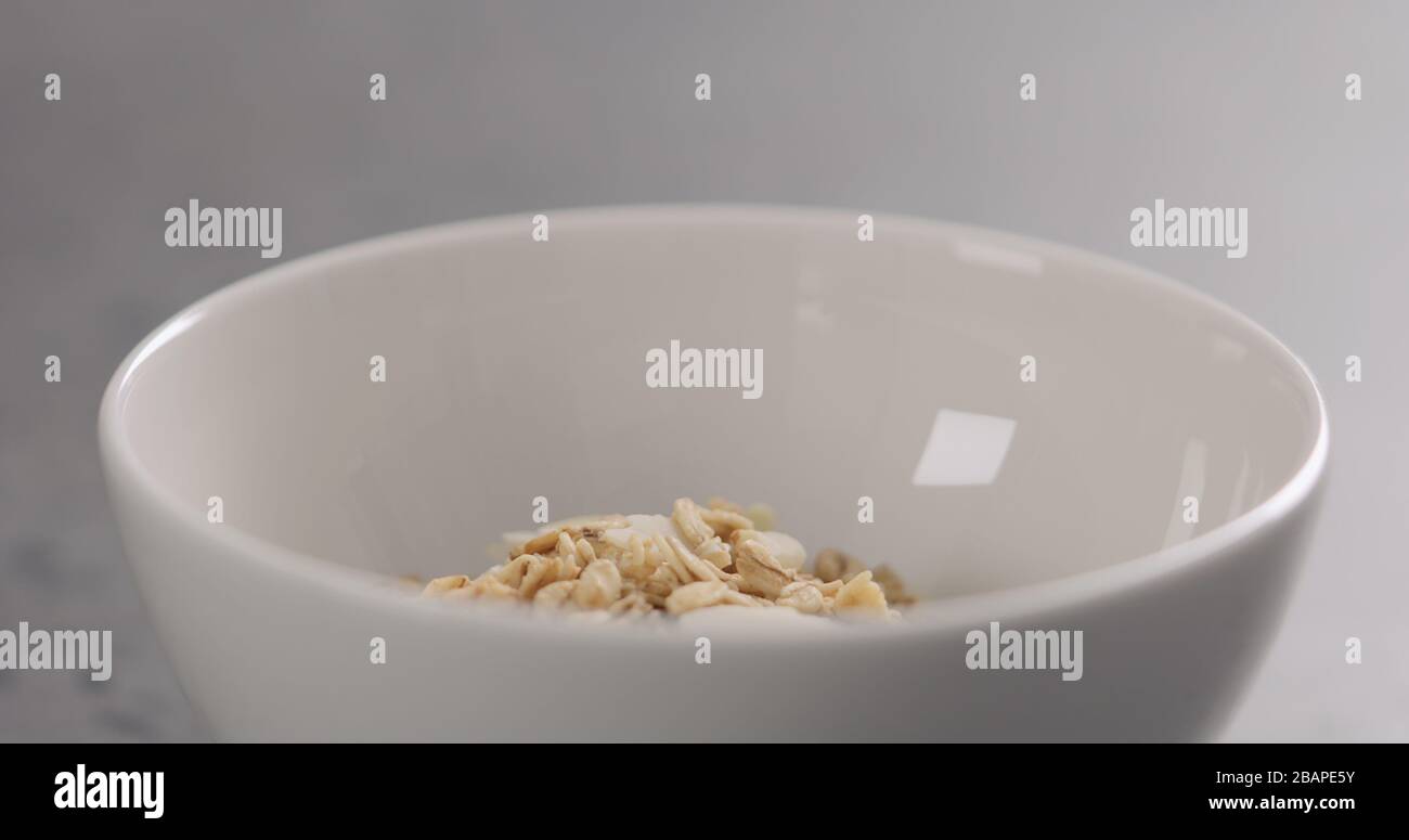 closeup granola with almond flakes in white bowl, wide photo Stock ...