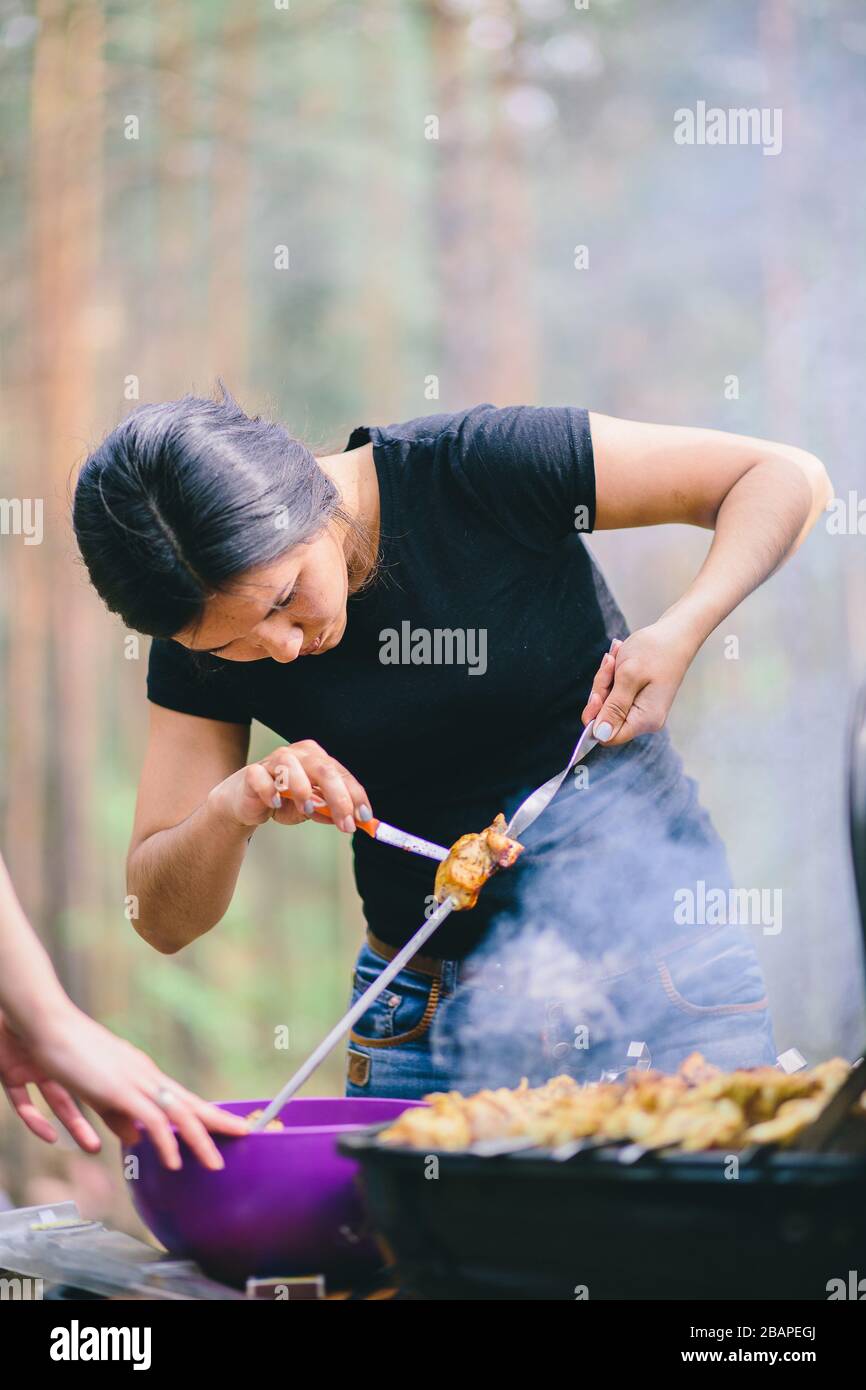 woman preparing meat on the grill in the woods Stock Photo - Alamy