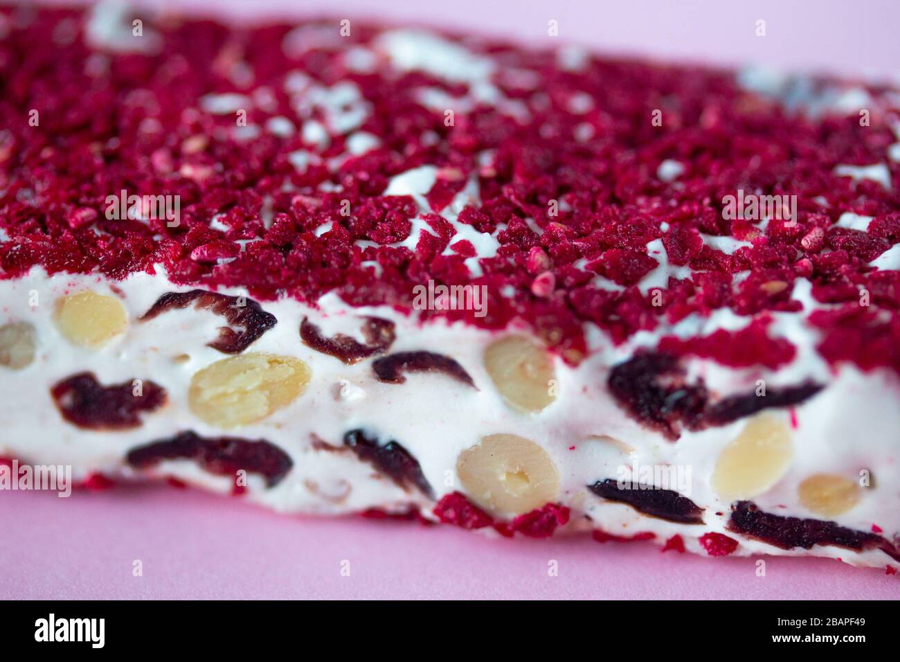 Torrone or nougat bar with nuts and red dried berries. Traditional ...