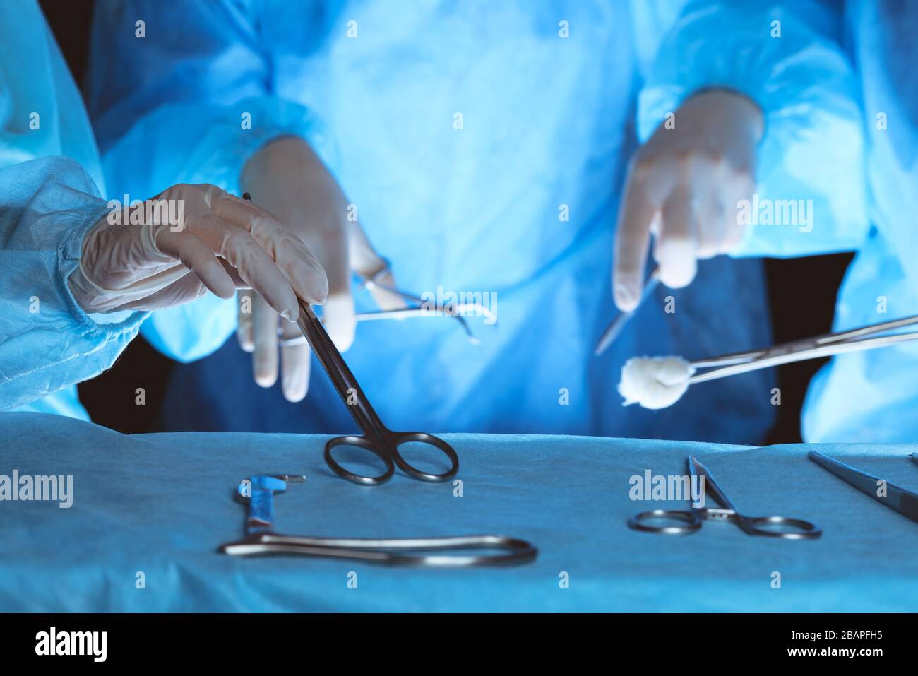 Group of surgeons wearing safety masks performing operation. Close-up ...