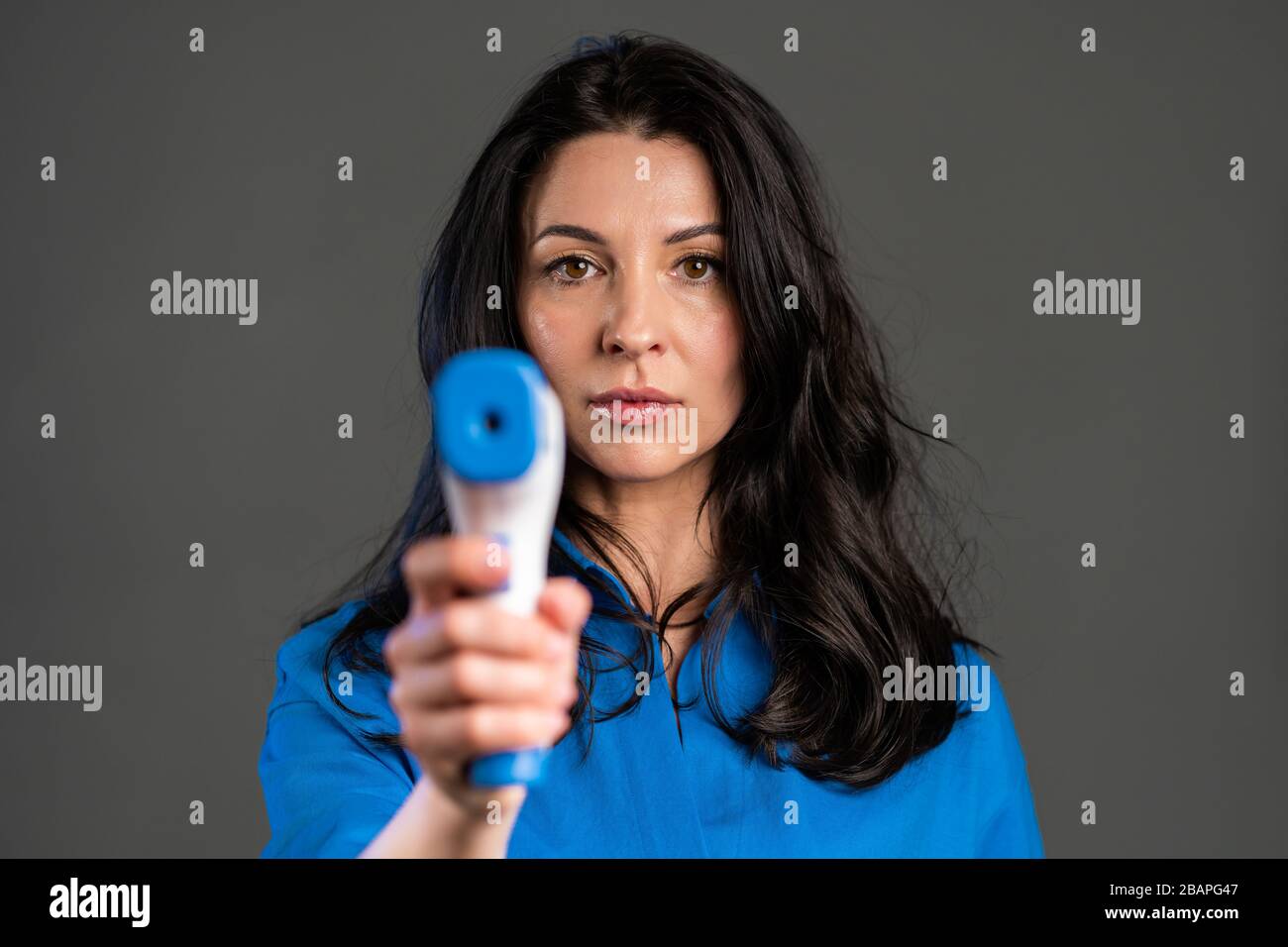 Beautiful adult woman uses an electronic thermometer to measure ...