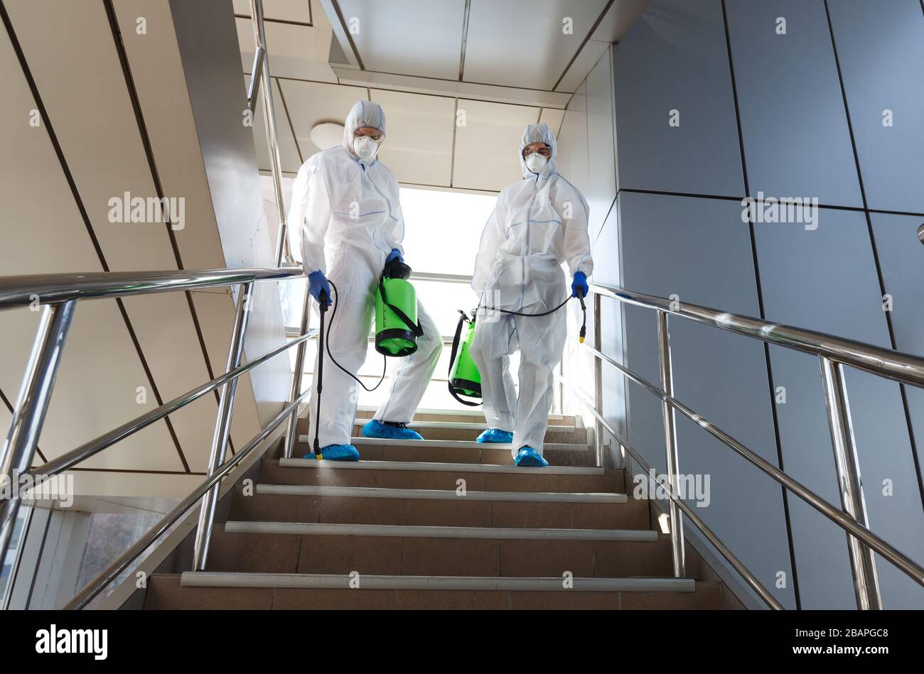 Men in virus protective suits carrying barrels, pathogen respiratory ...
