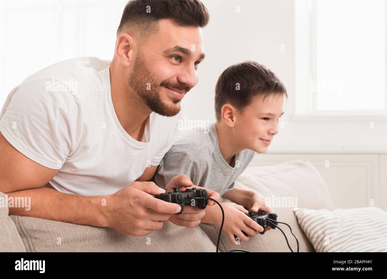 Self-isolated dad and son playing video games at home Stock Photo - Alamy