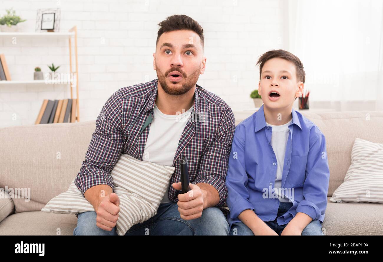 Dad and son enjoying tv at home, empty space Stock Photo - Alamy