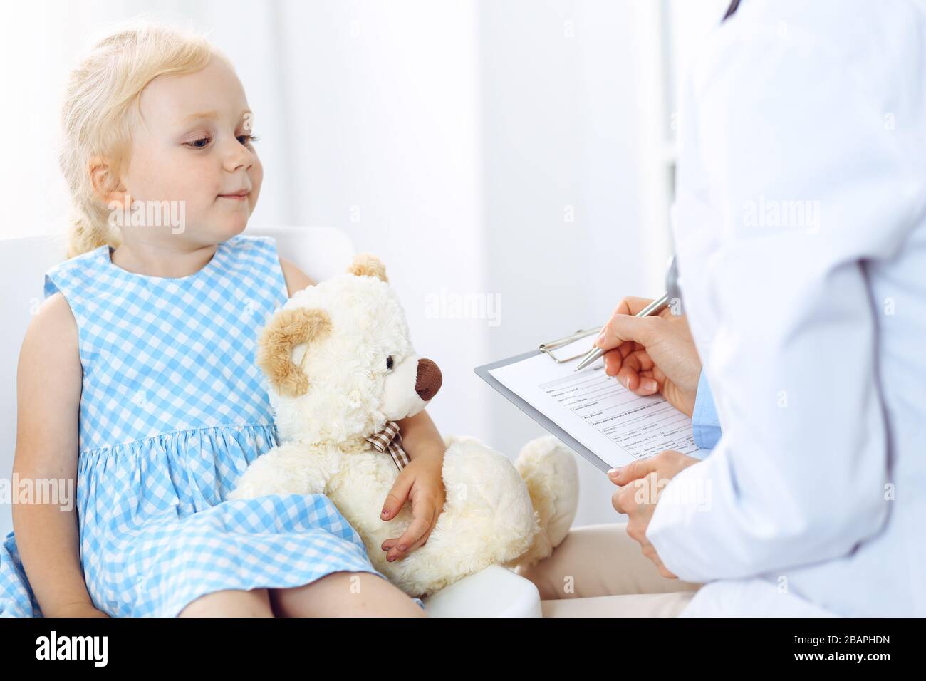 Happy smiling child patient at usual medical inspection. Doctor and ...