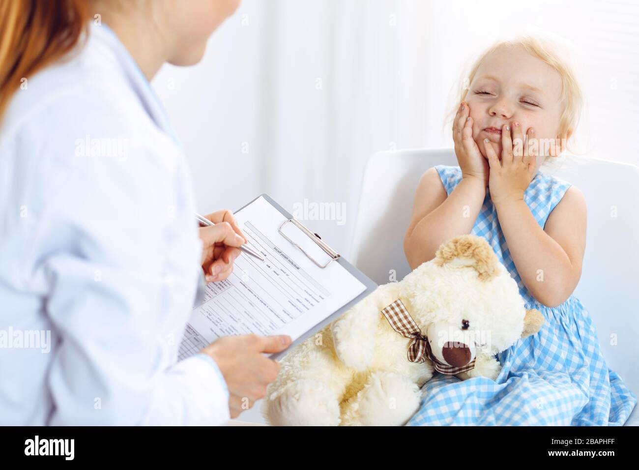 Happy smiling child patient at usual medical inspection. Doctor and ...