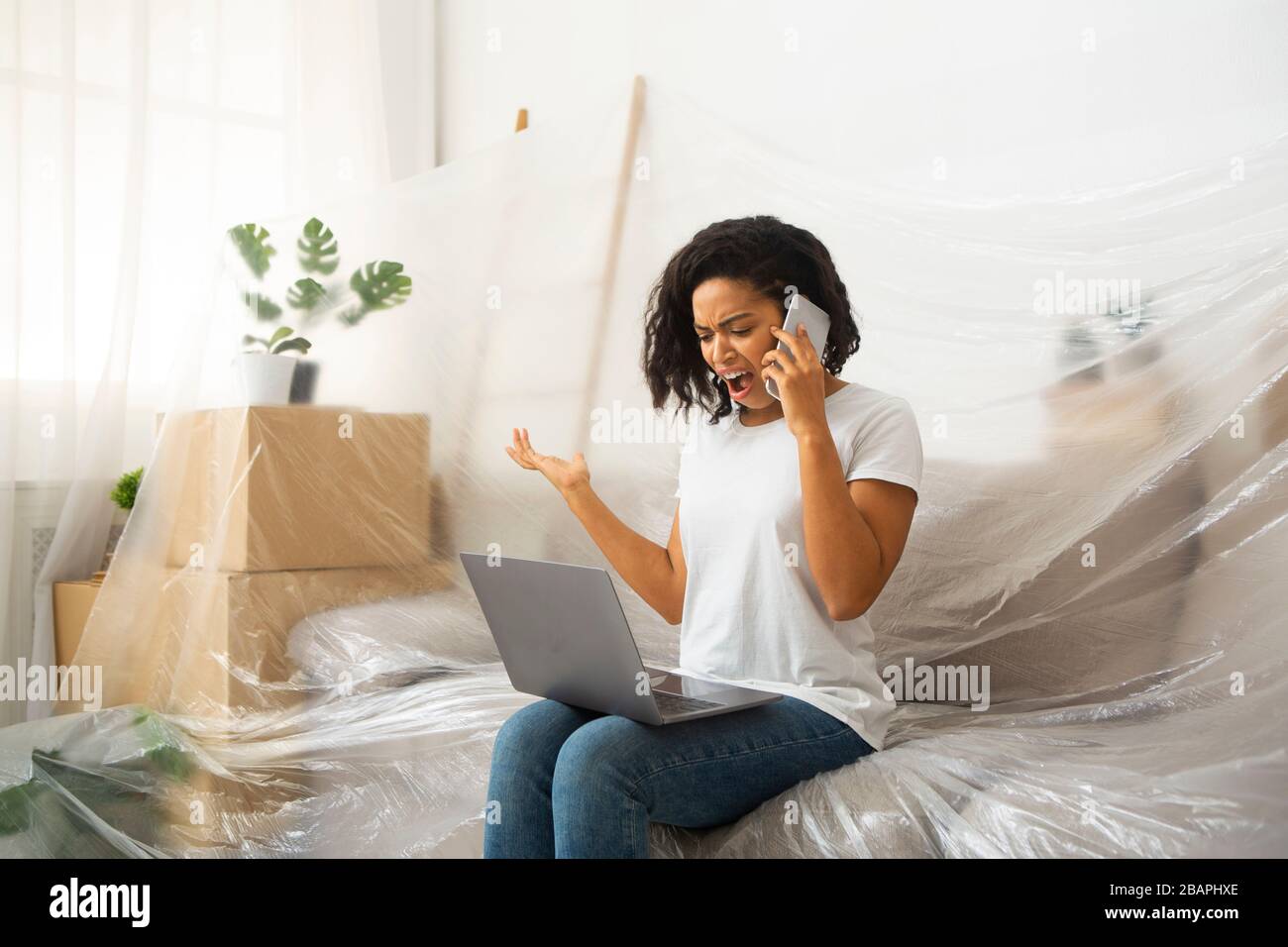 Millennial girl cursing in phone during repair Stock Photo - Alamy
