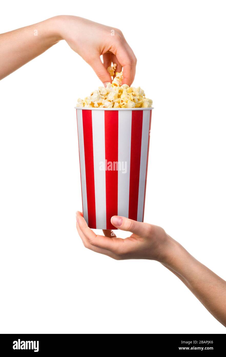 Woman hand taking popcorn from striped bucket isolated on white ...