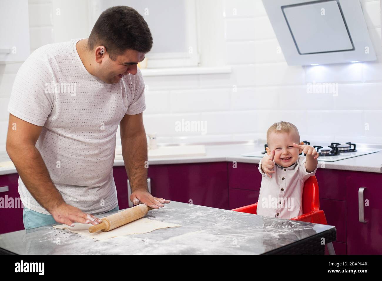 Kid rolls out the pizza dough. Happy family in kitchen Stock Photo - Alamy Kid rolls out the pizza dough. Happy family in kitchen Stock Photo - Alamy