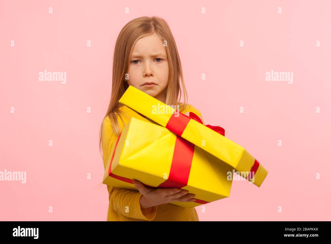 Funny cute child unhappy with bad birthday present. Portrait of sad ...