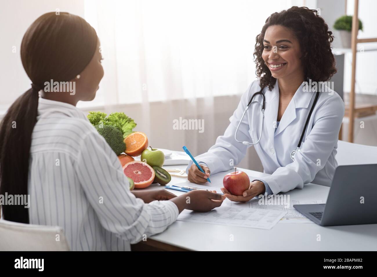 Happy nutritionist giving consultation to patient about healthy feeding ...