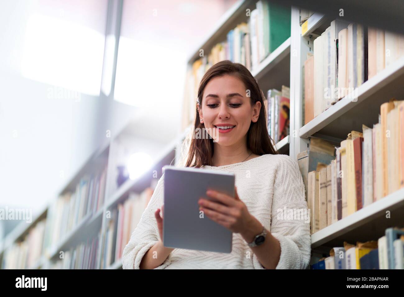 Young female student studying in the library Stock Photo - Alamy