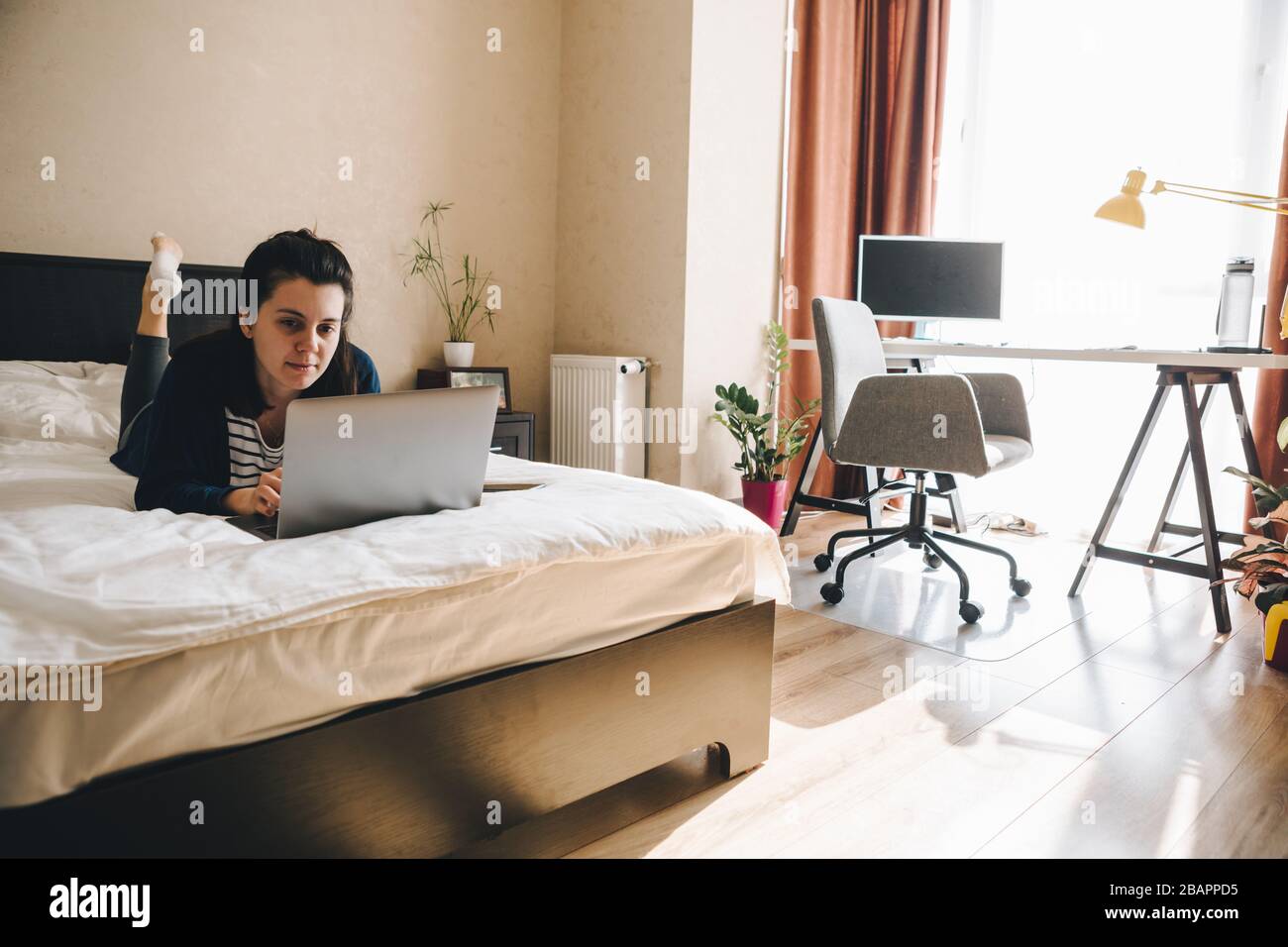 woman laying on bed with laptop Stock Photo - Alamy