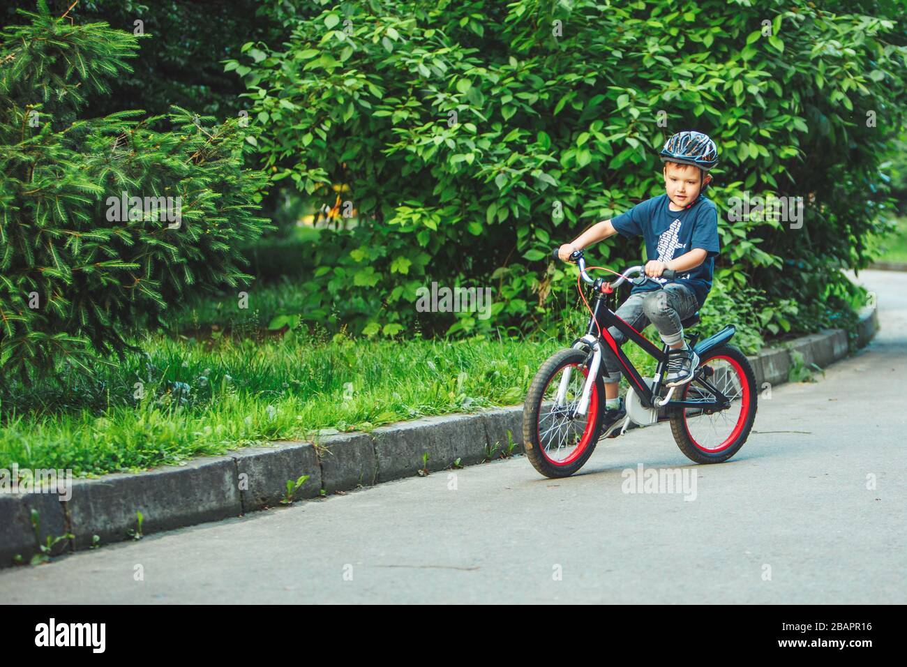 little boy riding on bicycle in helmet Stock Photo - Alamy