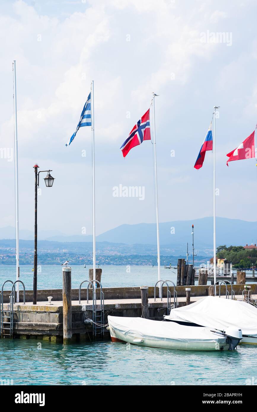 Port on Lake Garda. Flags of European countries. Summer landscape ...