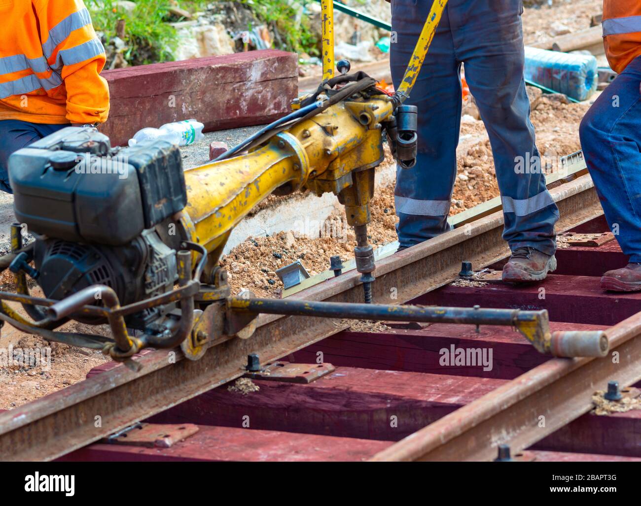 Railway workers bolting track rail. Detail worker with mechanical ...