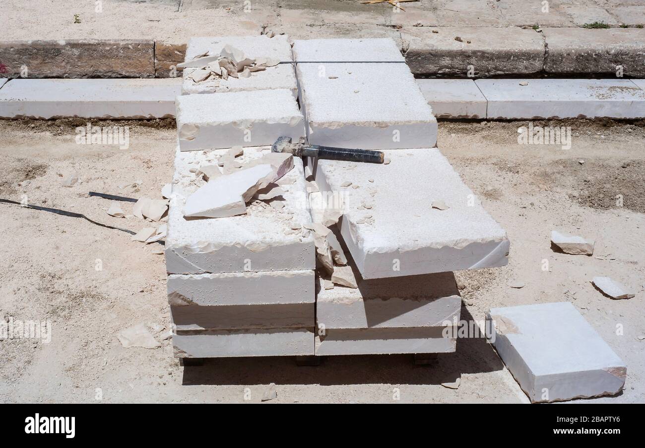 Closeup of a large piece of marble and a hammer after splitting marble ...