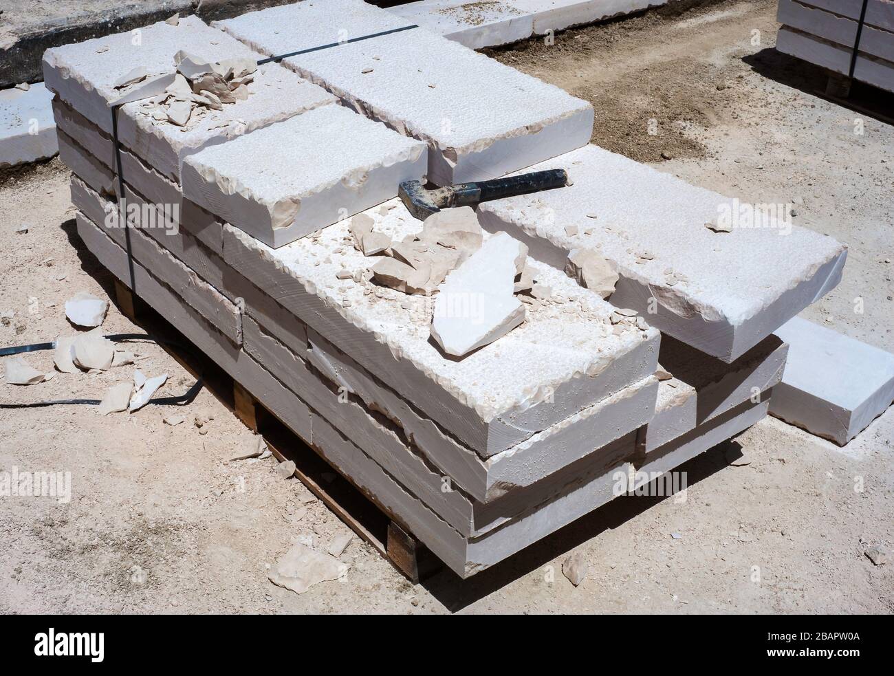 Closeup of a large piece of marble and a hammer after splitting marble ...