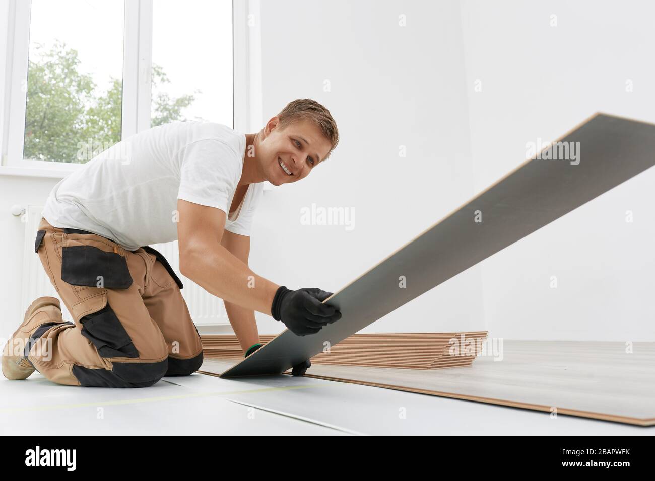 Laying laminate flooring. Adult man lays the laminate panel on the ...
