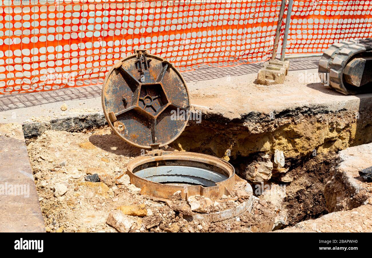 Sewer cover runneth over spilling water into Stock Photo - Alamy