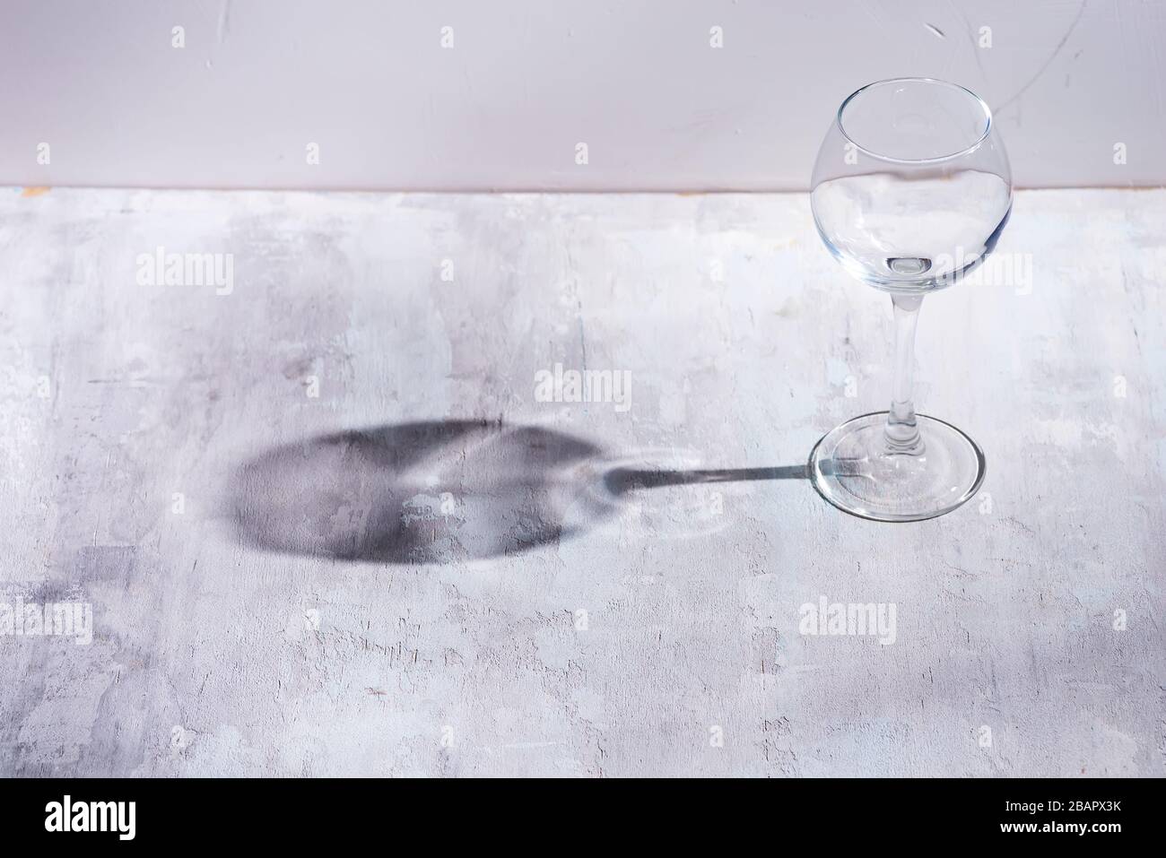 Wine glass with sun hard light shadow reflection on stone background ...